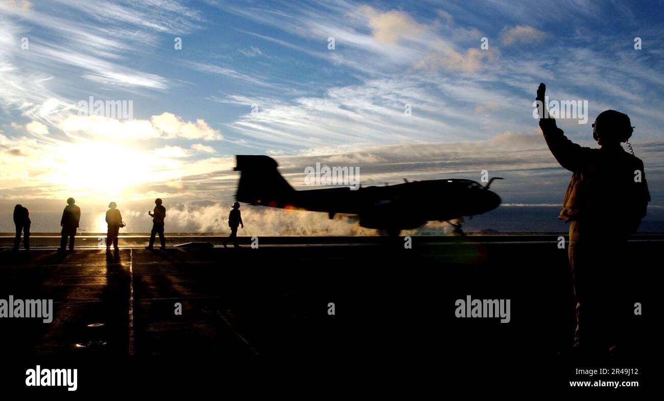 US Navy A flight deck officer signals as an EA-6B Prowler launches from ...