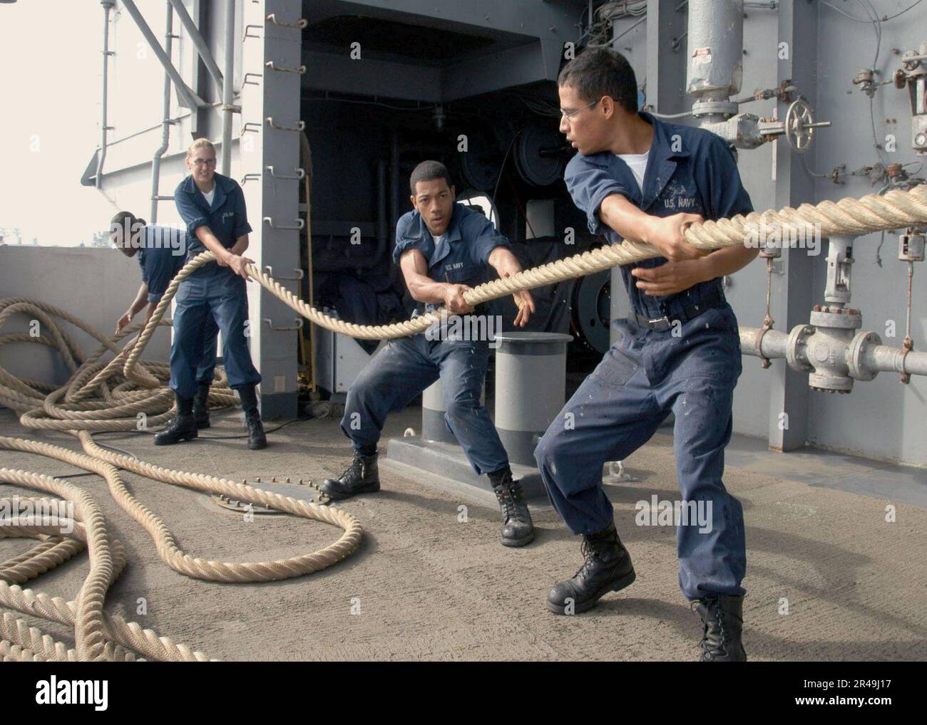US Navy Four line handlers heave in one of the mooring lines Stock ...