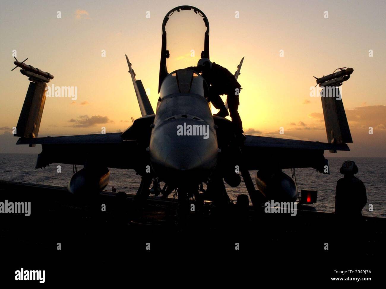 US Navy A naval aviator enters the cockpit of an F-A-18C Hornet prior ...