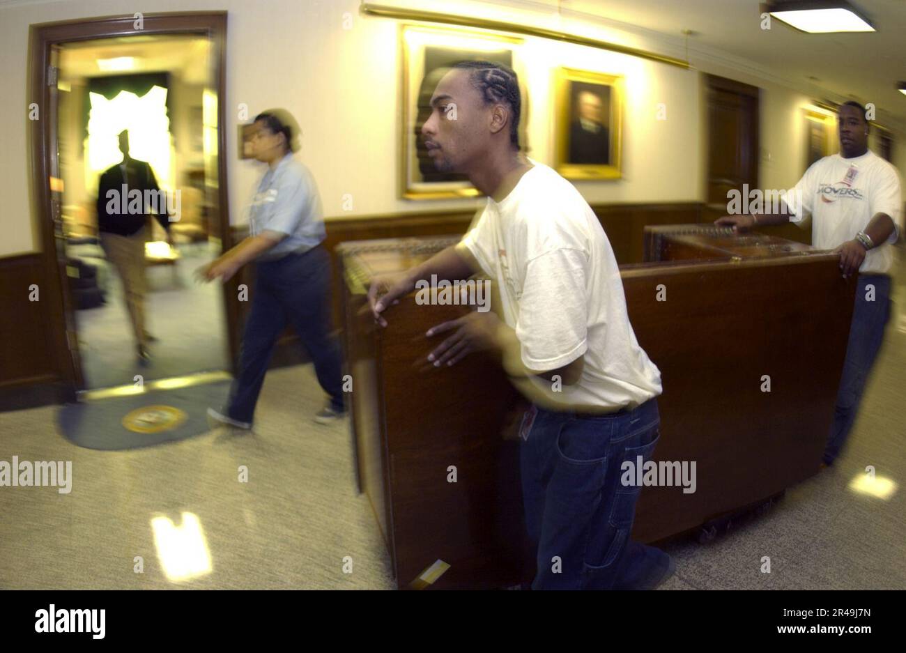 US Navy Office Mover employees wheel the Secretary of the Navy's desk ...