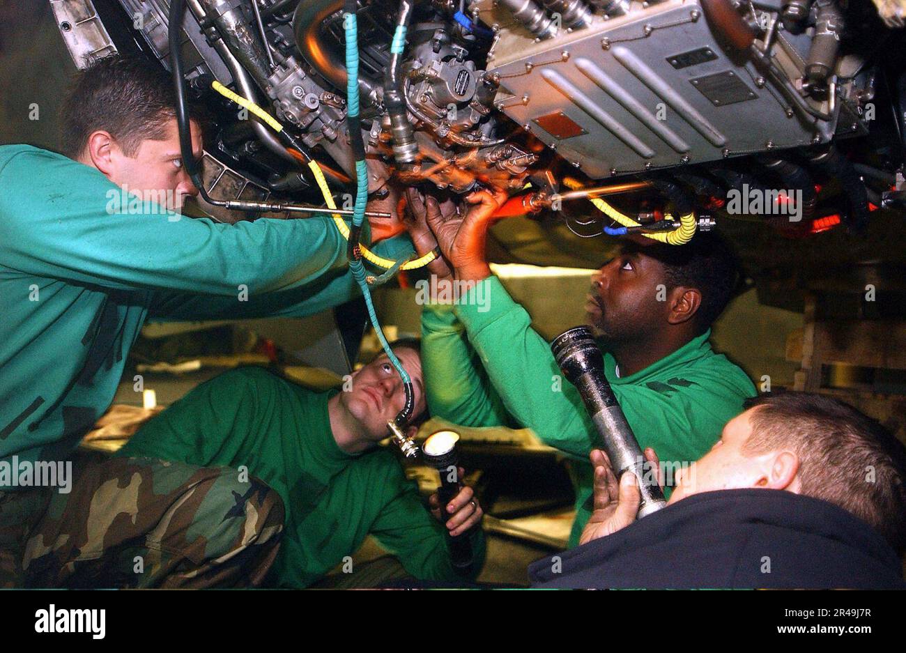US Navy Sailors perform scheduled maintenance on an F-14 Tomcat jet ...