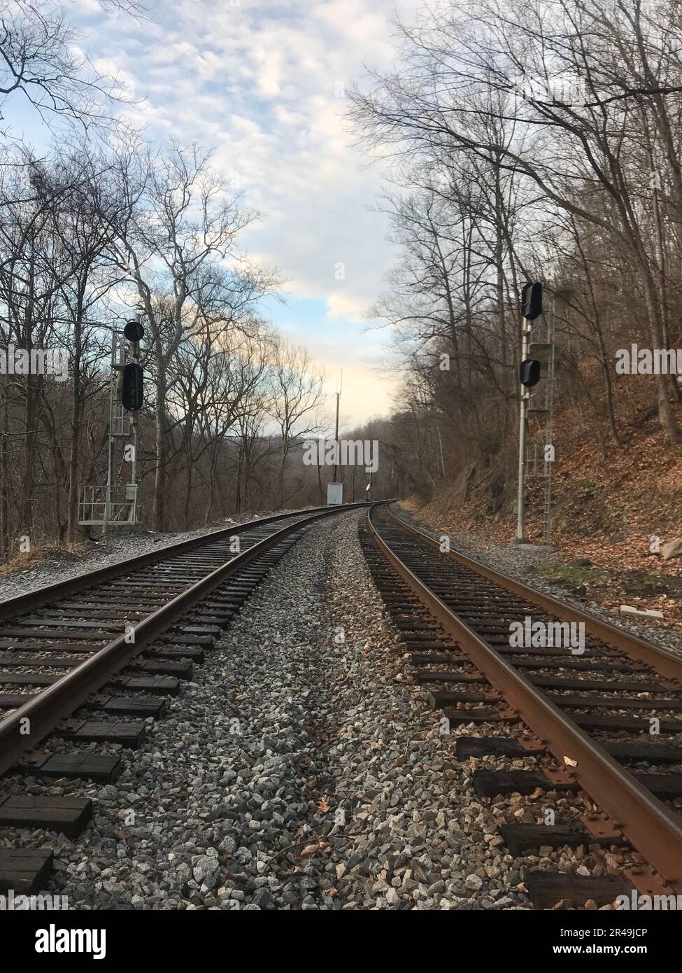 A scenic view of a railway crossing, featuring a single signal post set ...