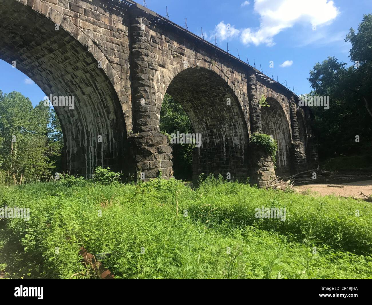 A stunning stone arch bridge in the middle of a vibrant landscape ...