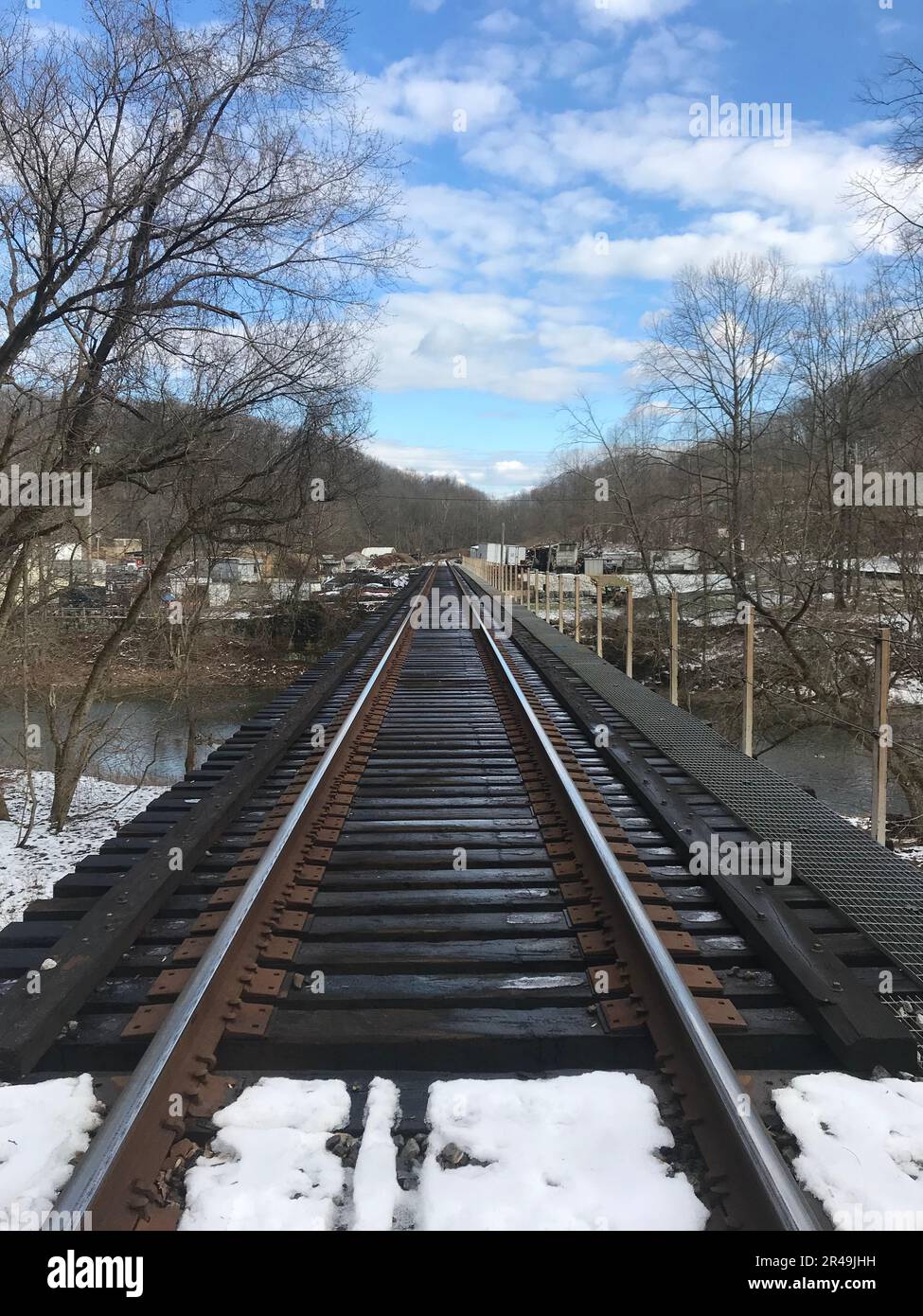 A train line running through a residential area next to a large body of ...