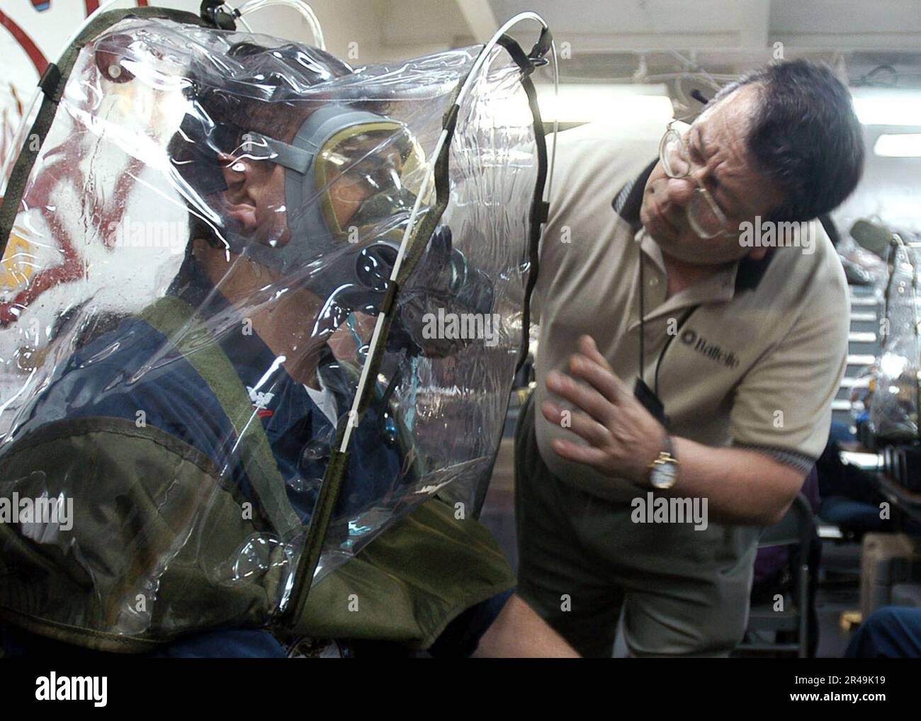 US Navy Contractors check the fit on a MCU-2P gas mask worn by a Sailor ...