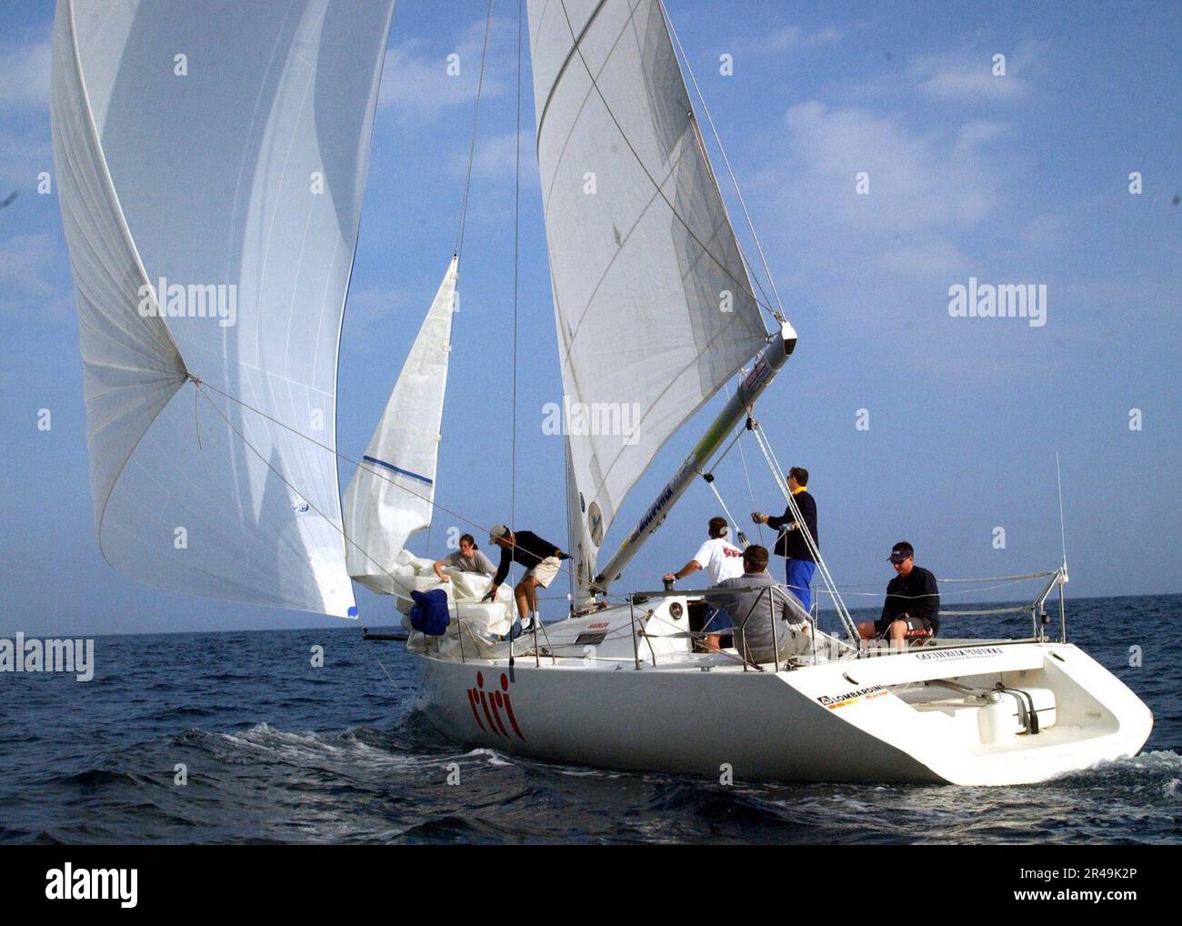US Navy Members of the U.S. Military Sailing team stow the jib sail and raise the spinnaker ...