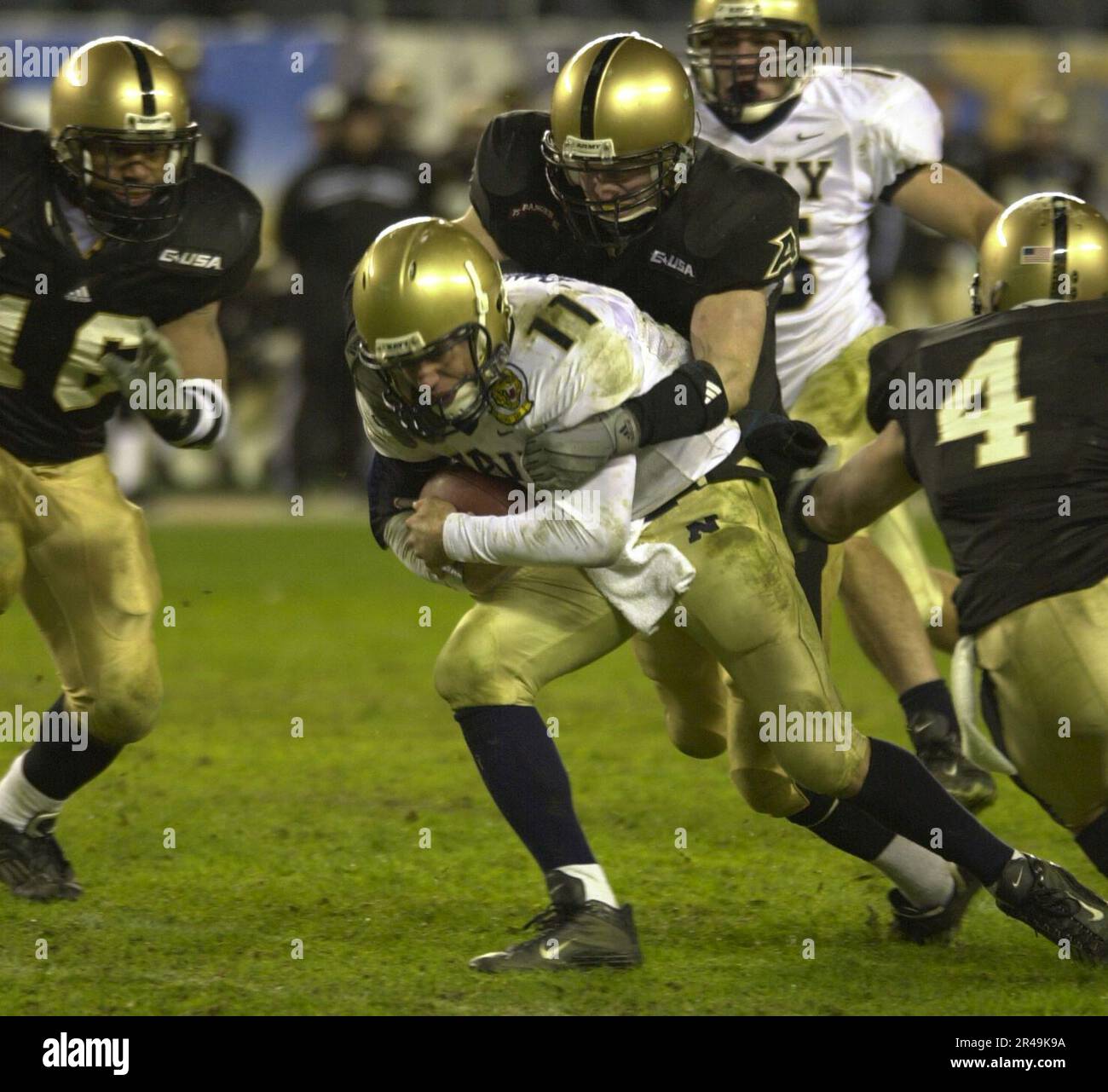 US Navy Navy quarterback is wrapped up by an Army defender during the ...