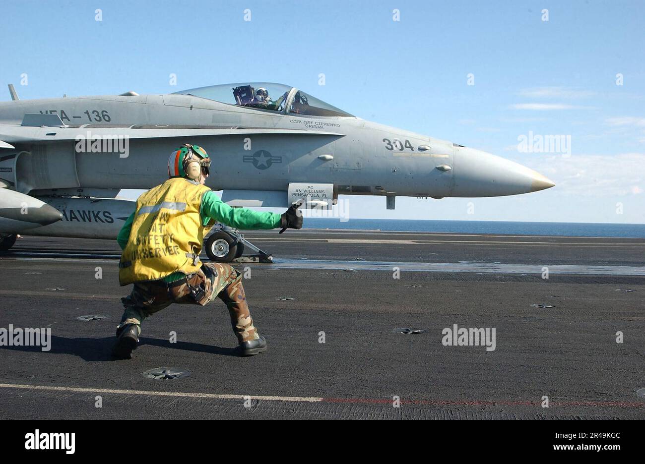 US Navy Bow catapult safety observer Aviation Boatswain's Mate gives ...