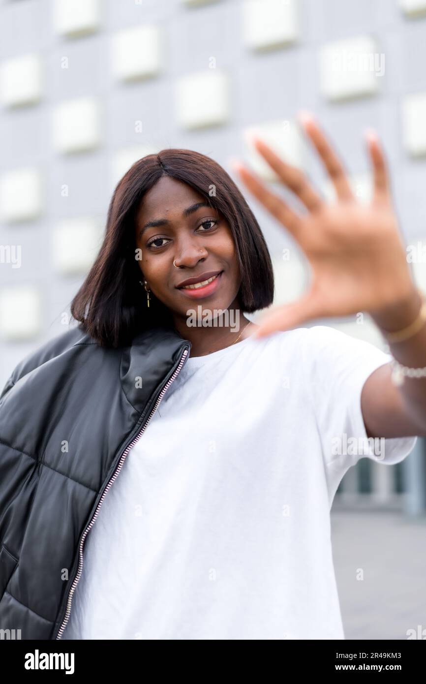 A confident black female in a white shirt exuberant pose reaching to ...