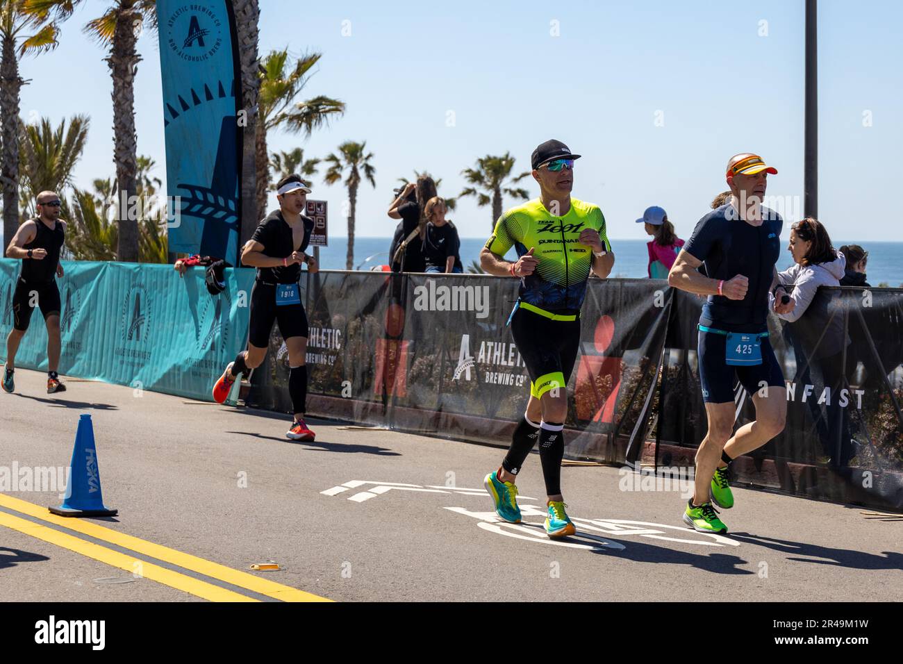 Participants compete in the run portion of the Ironman 70.3 Oceanside race at the Oceanside Pier ...