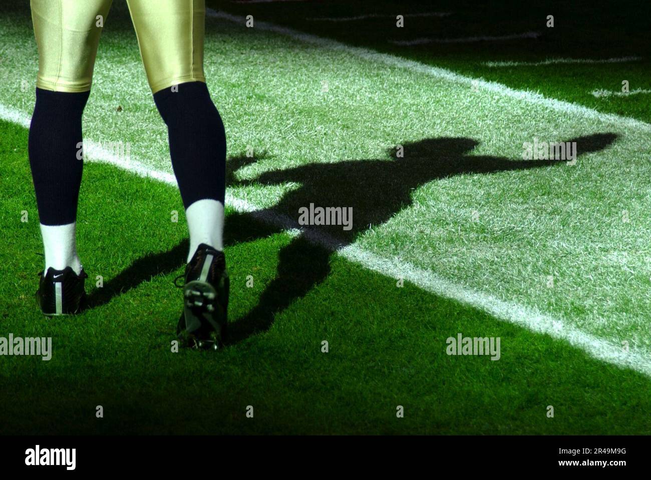 US Navy A Navy football player warms up by passing a football prior to ...