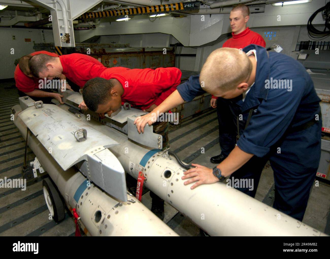 US Navy Aviation Ordnanceman install a launcher on a inert High-Speed ...