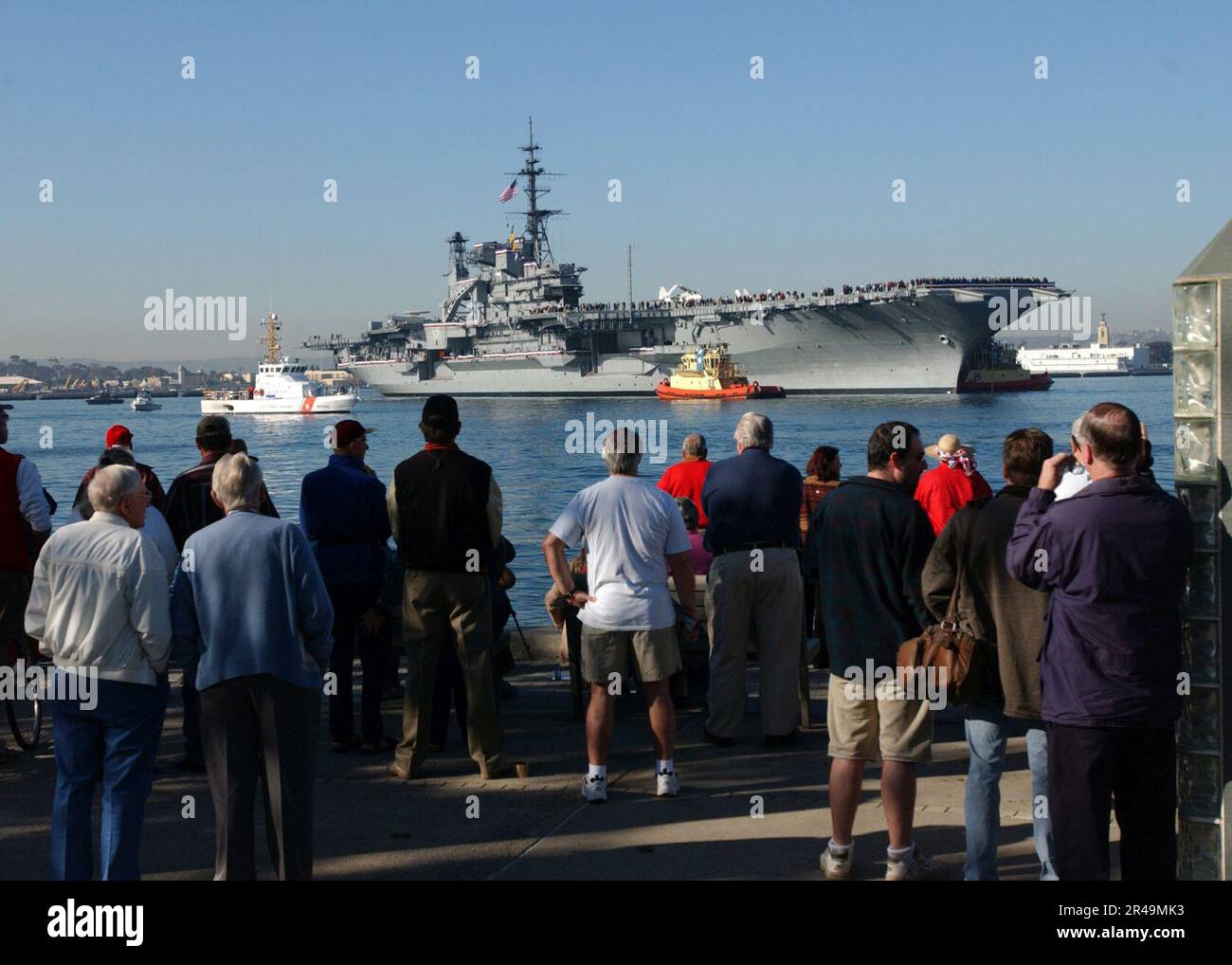 US Navy Spectators view the carrier Midway as she is moved into her ...