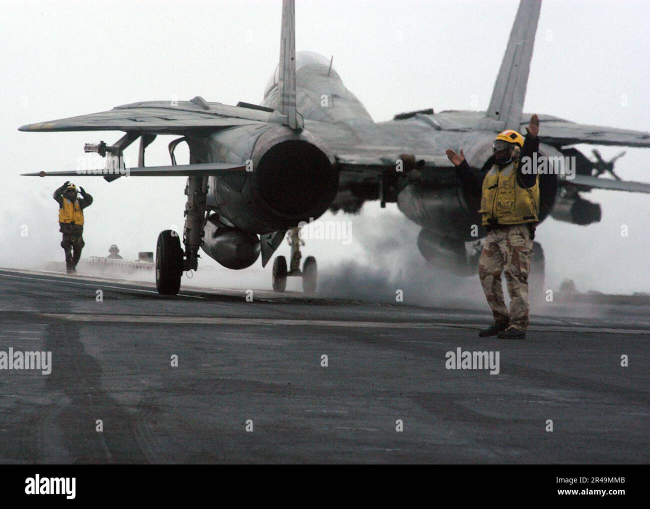 US Navy Flight deck personal direct an F-14 Tomcat assigned to the ...