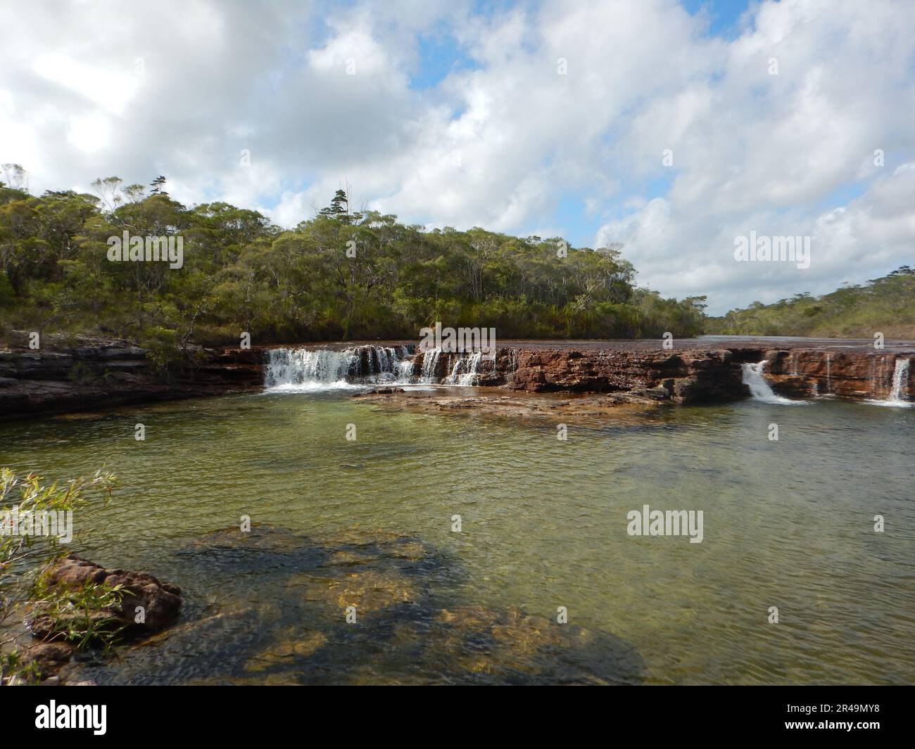 A scenic landscape featuring a series of cascading waterfalls flowing ...