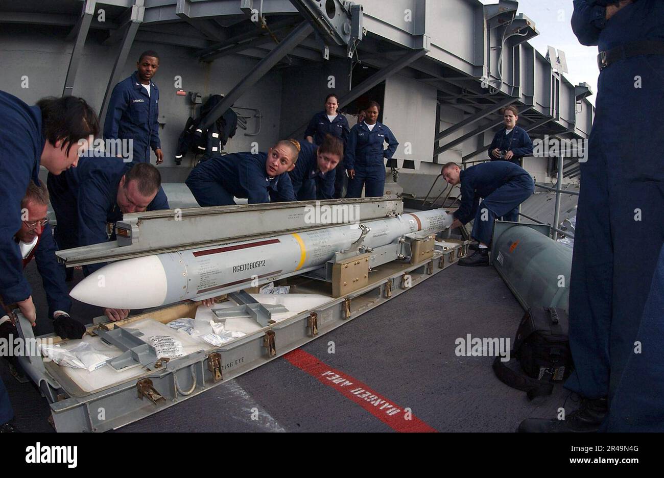 US Navy Fire Controlman work as a team to load a NATO Sea Sparrow ...