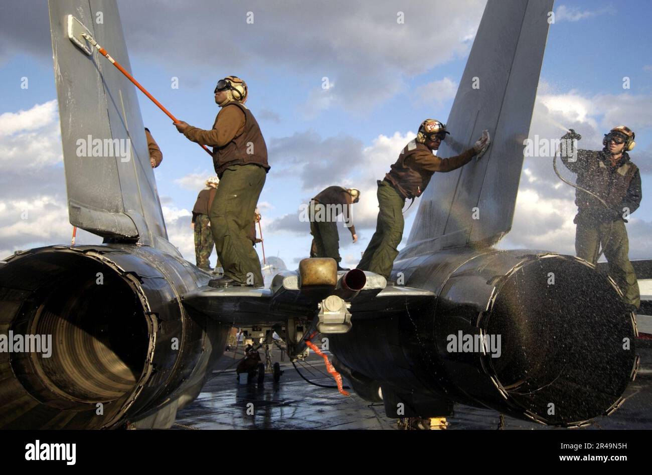 US Navy Sailors assigned to the Red Rippers of Fighter Squadron One One (VF-11) wash an F-14 ...