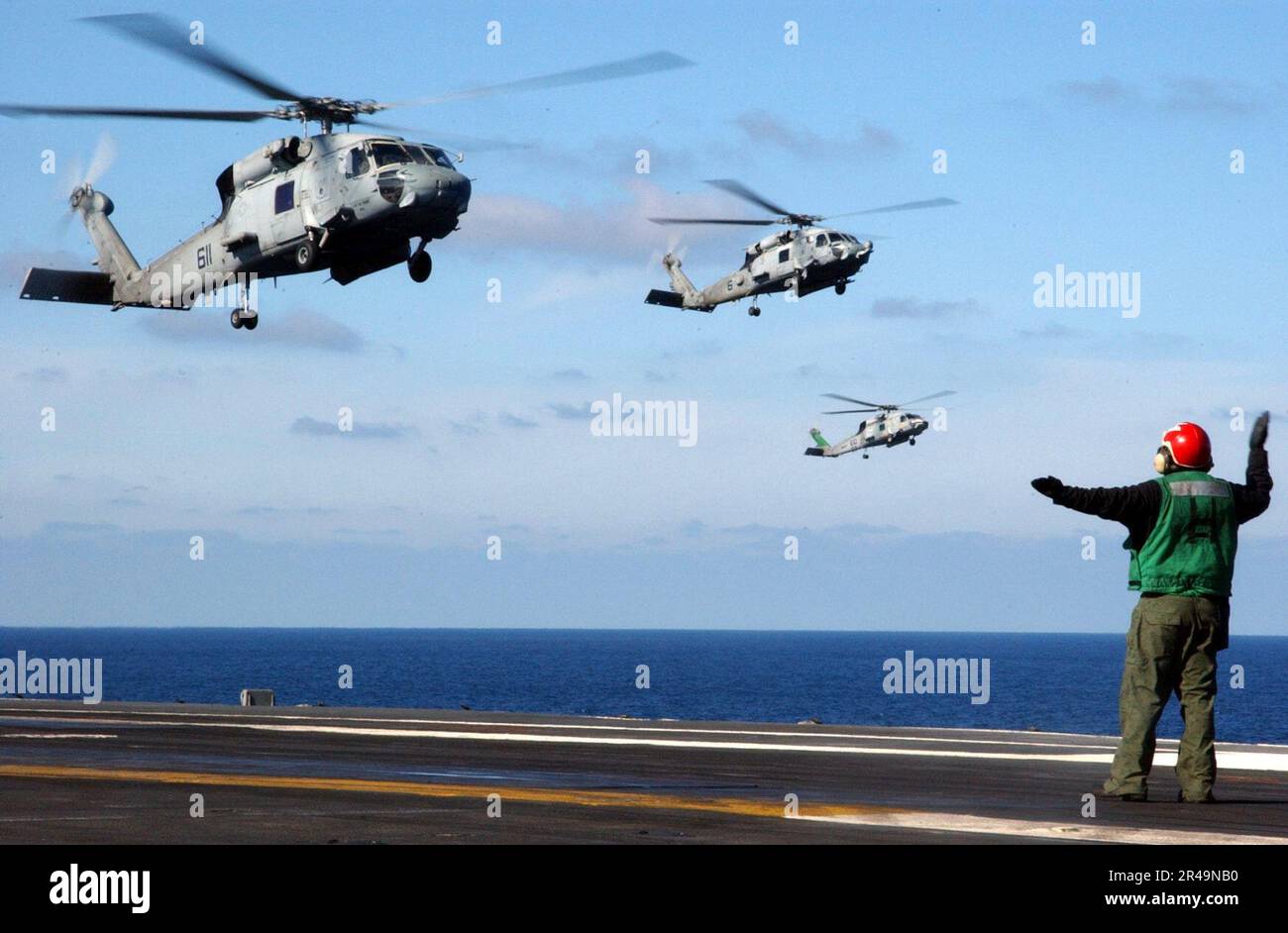 US Navy A Landing Signals Enlisted (LSE) directs one of three incoming ...