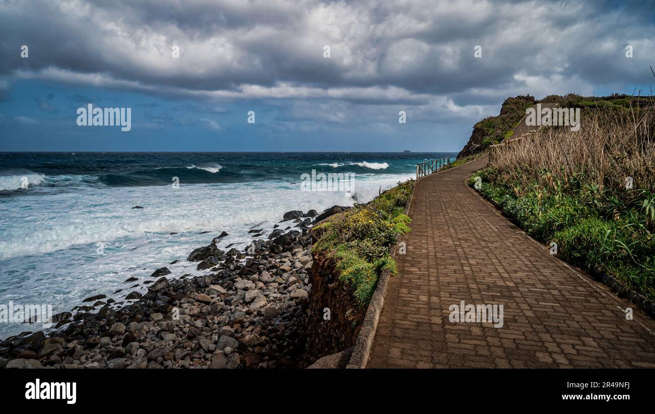 A pathway on the side of a rock cliff with water below, Madeira ...