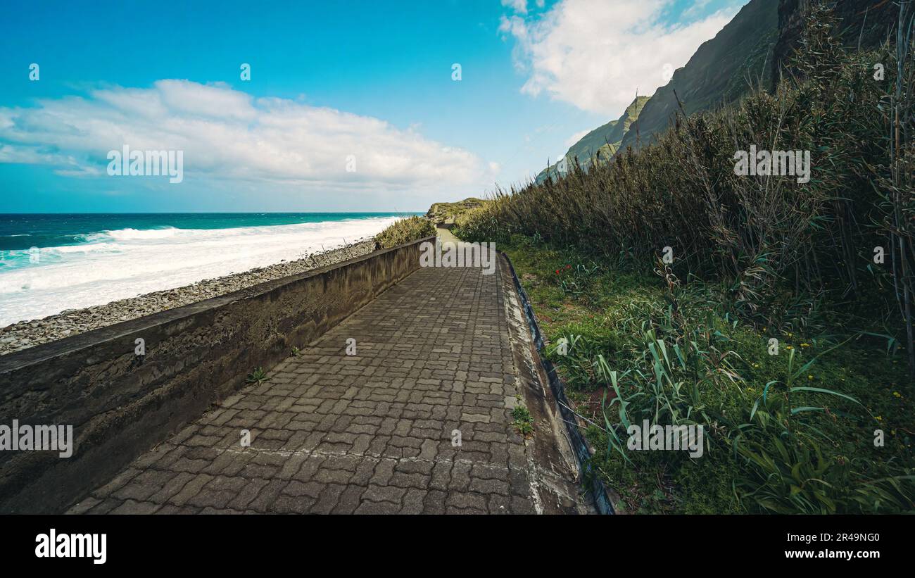 A sidewalk between paths leads to the water and beach, Madeira ...