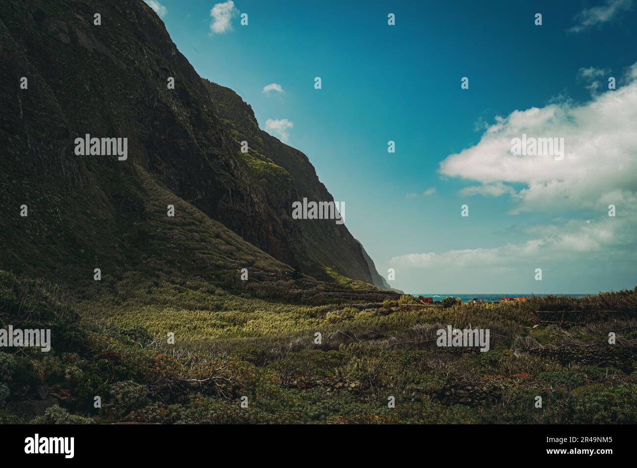 A stunning mountain valley, surrounded by lush vegetation and ...