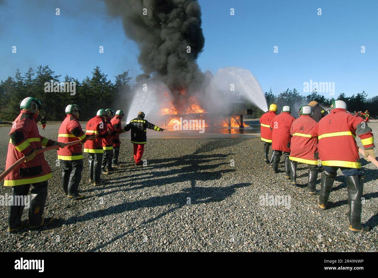 US Navy Two hose teams advance and engage their hoses on a fire ...