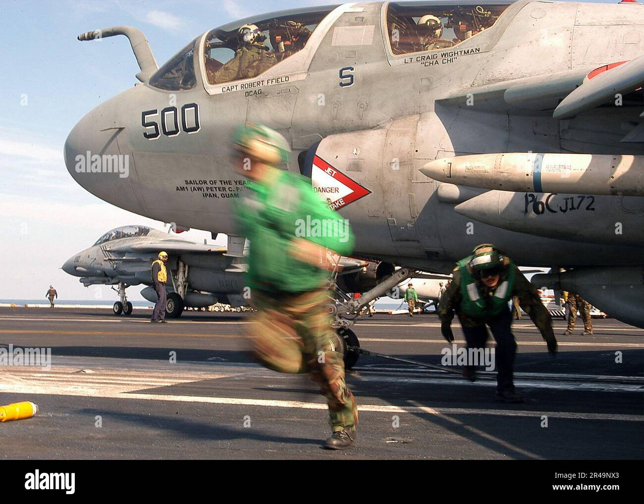 US Navy Aviation Boatswain's Mates clear the launch path of an EA-6B ...