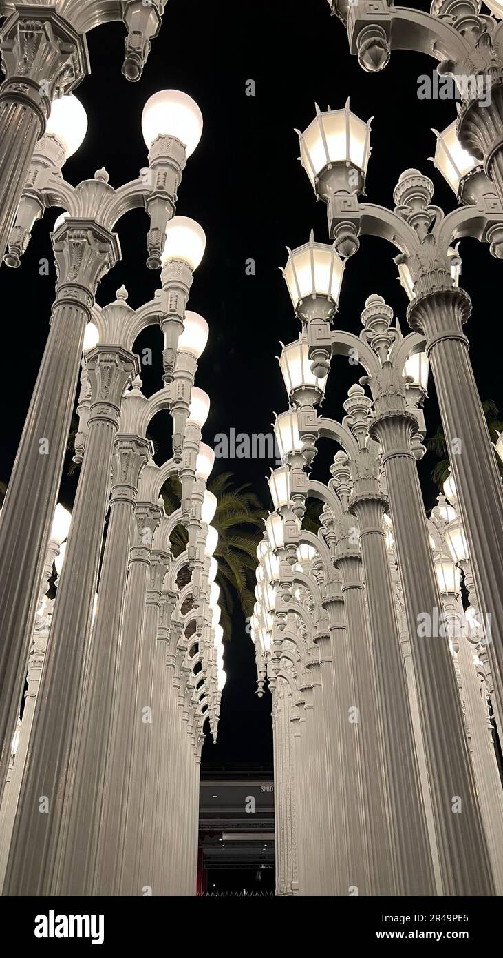 An illuminated scene of a city street at night featuring a row of ...