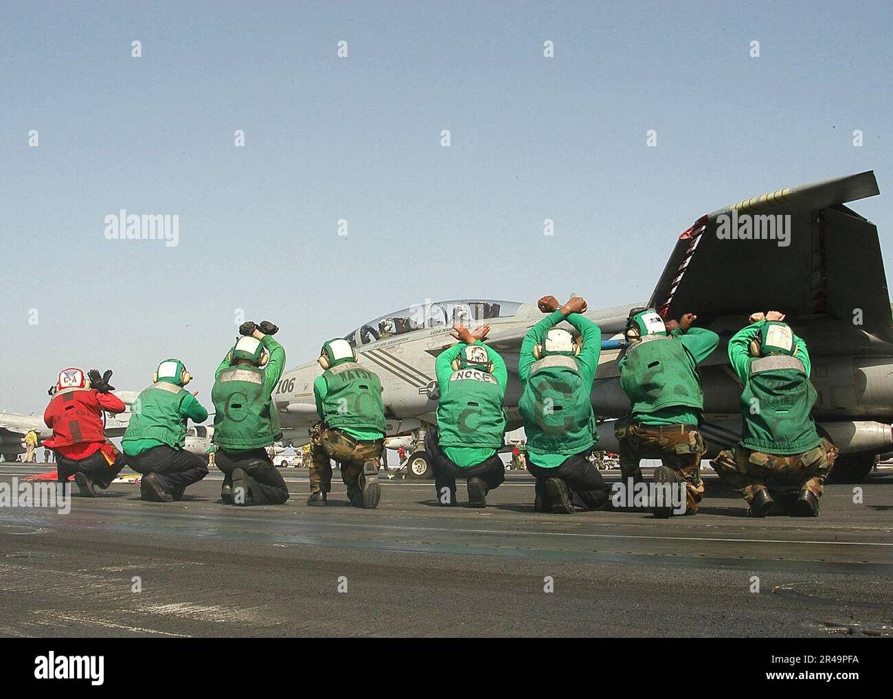 US Navy Flight deck crewmembers cross their arms to signal suspend the ...