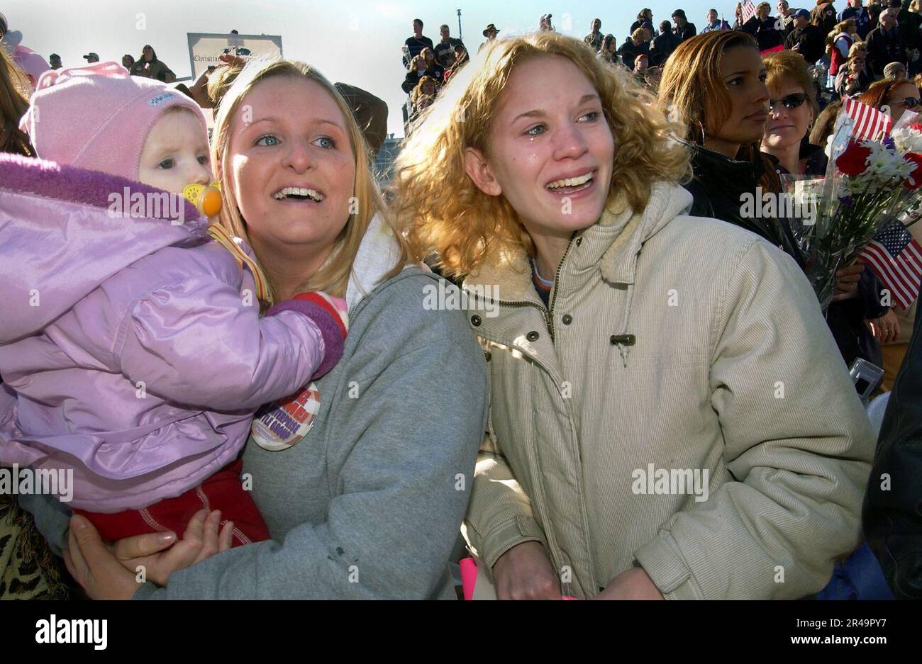 US Navy A loved one holds her daughter while she waits for her husband ...