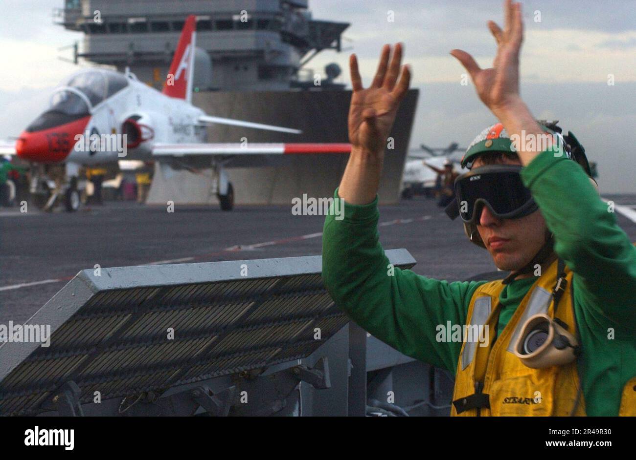 US Navy A flight deck crewman signals that he is about to launch a T ...
