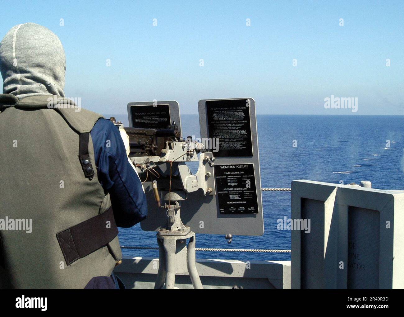 US Navy Signalman fires a .50 caliber machine gun mount during a ...