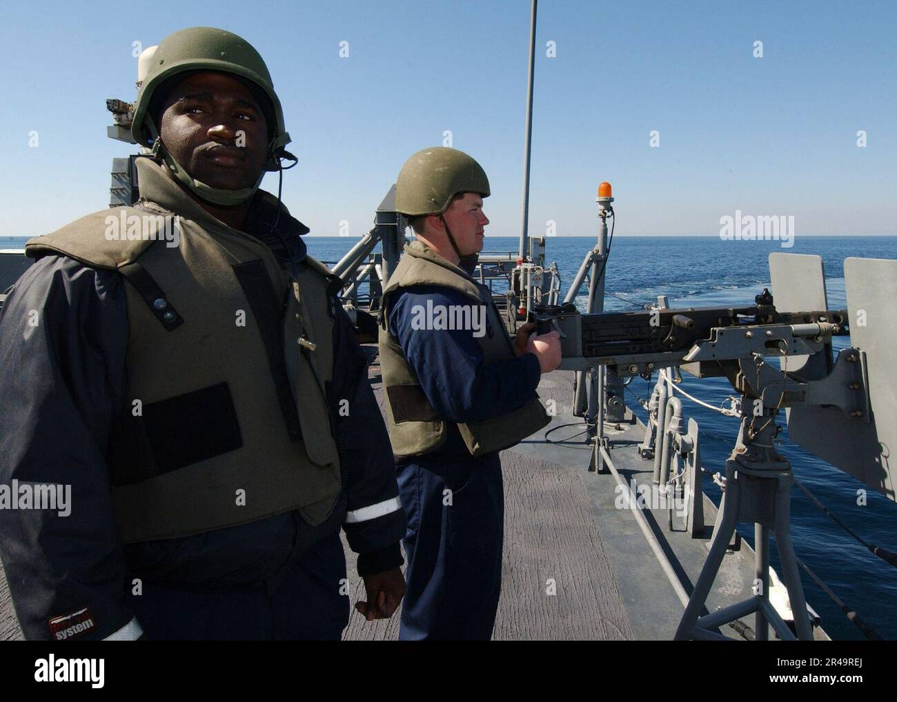 US Navy Sailors monitor surface contacts while manning a.50 caliber ...