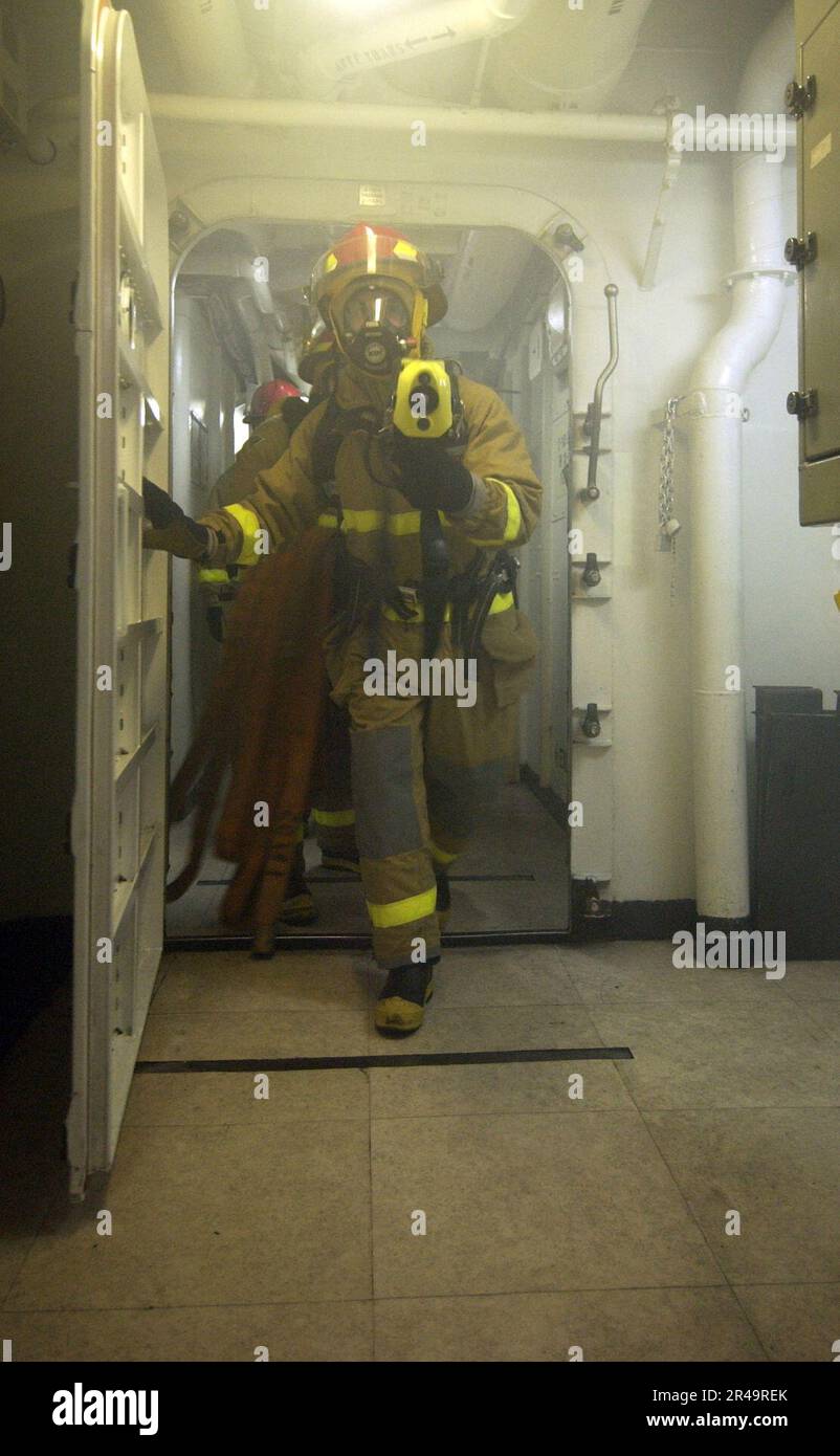 US Navy A fire fighting hose team investigates smoke on the forward ...