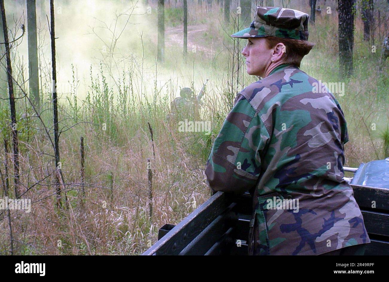 US Navy Capt. watches over the smoky battleground while members of ...
