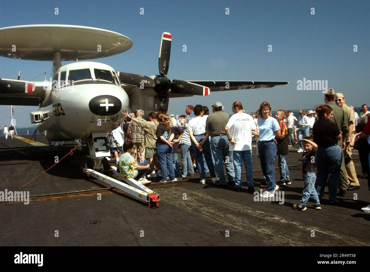 US Navy Excited visitors wait in line for their turn to embark on a ...