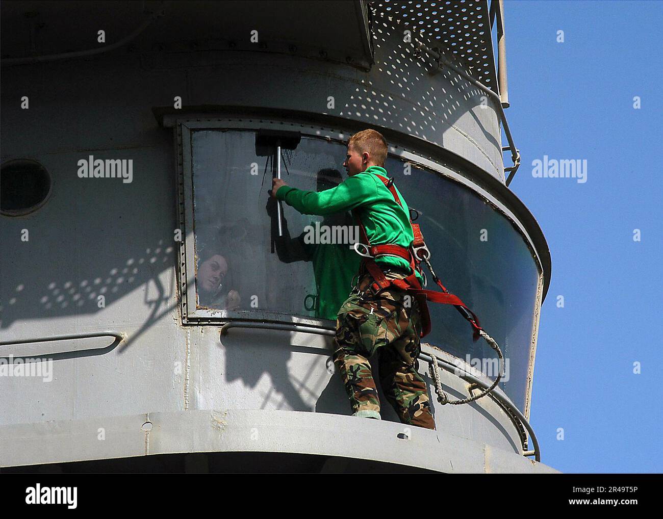 US Navy Airman cleans the window covering the Pilot Landing Air ...