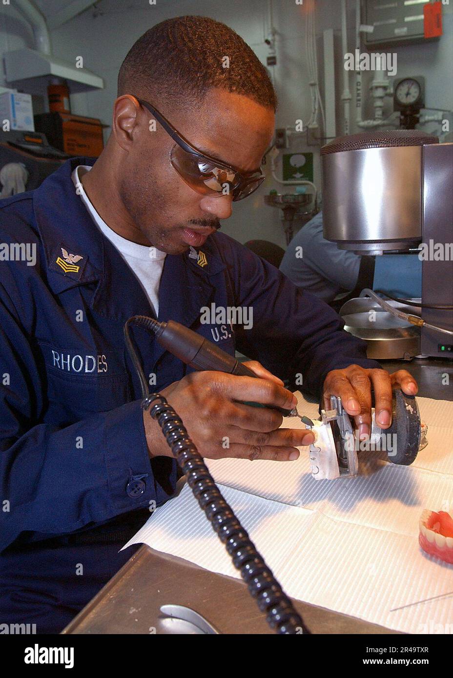 US Navy Dental Technician 1st Class shapes a mold for a temporary ...