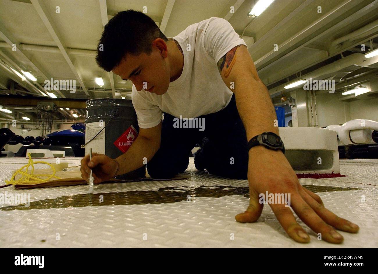 US Navy Seaman puts the finishing touches on a deck mural in the ...