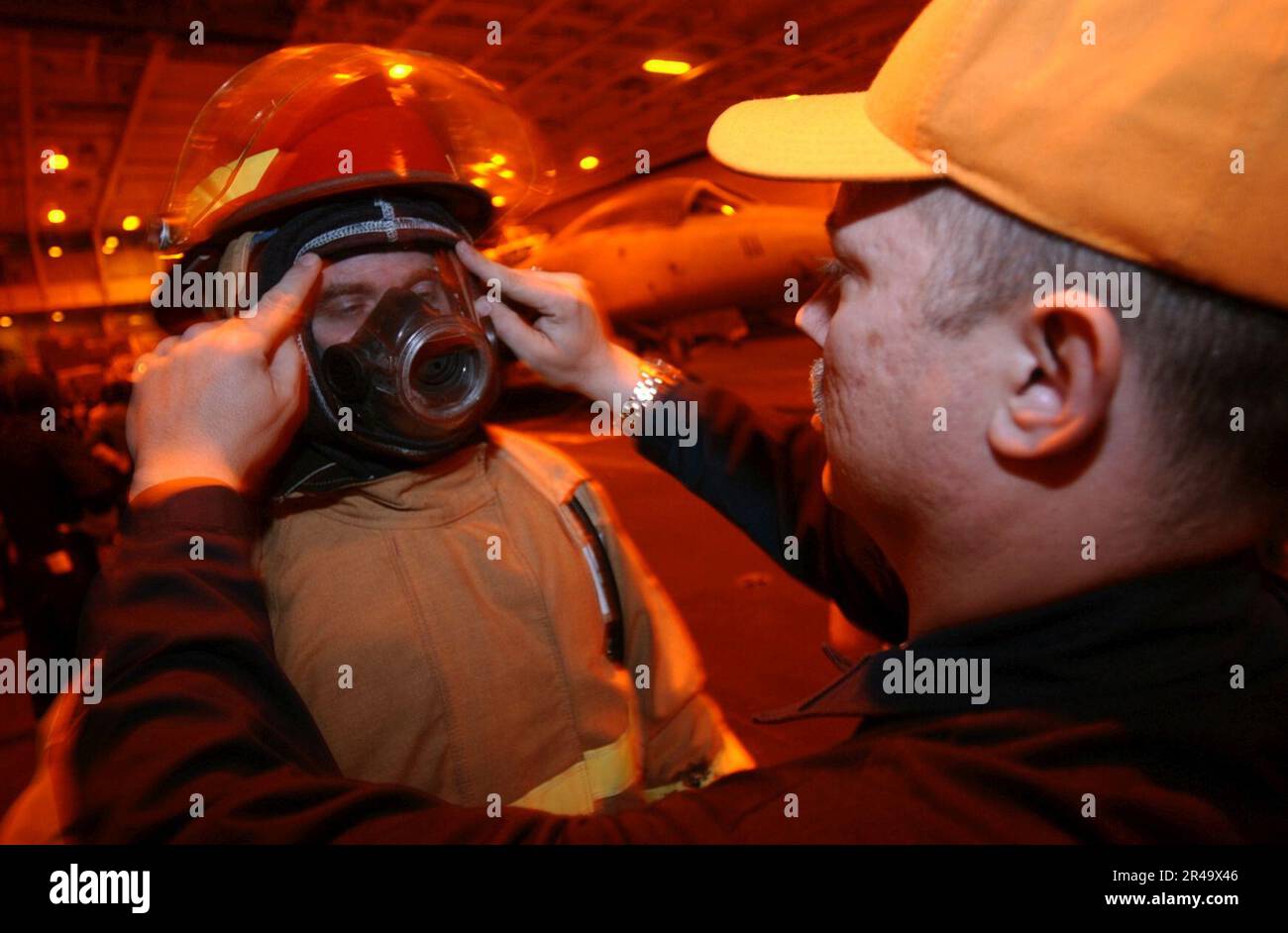 US Navy Aviation Electrician's Mate 1st Class overlooks a hose team ...