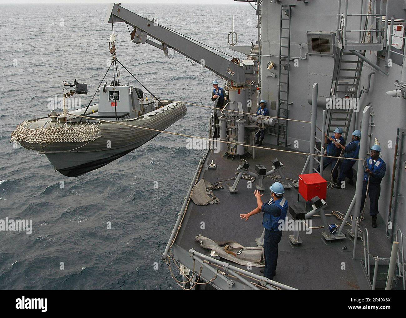 US Navy Crewmembers assigned to the Deck Department lower a Rigid Hull ...