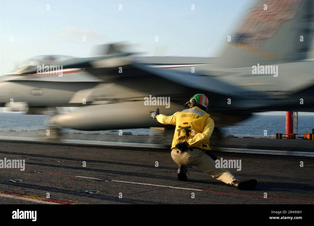 US Navy The Catapult Officer Shooter, gives the signal to launch an F-A ...