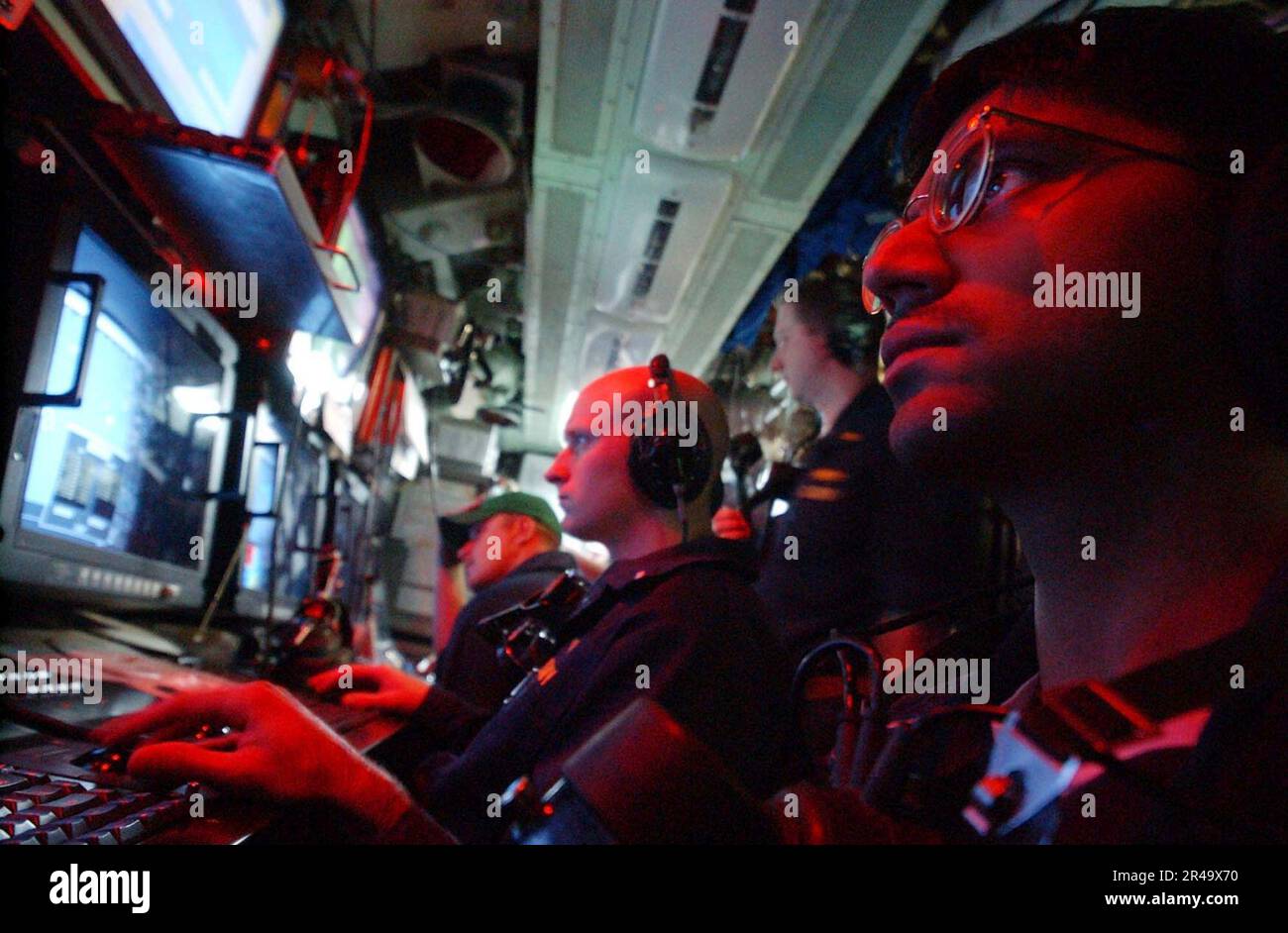 US Navy Lt. j.g. right, mans a console in the control room of the fast ...
