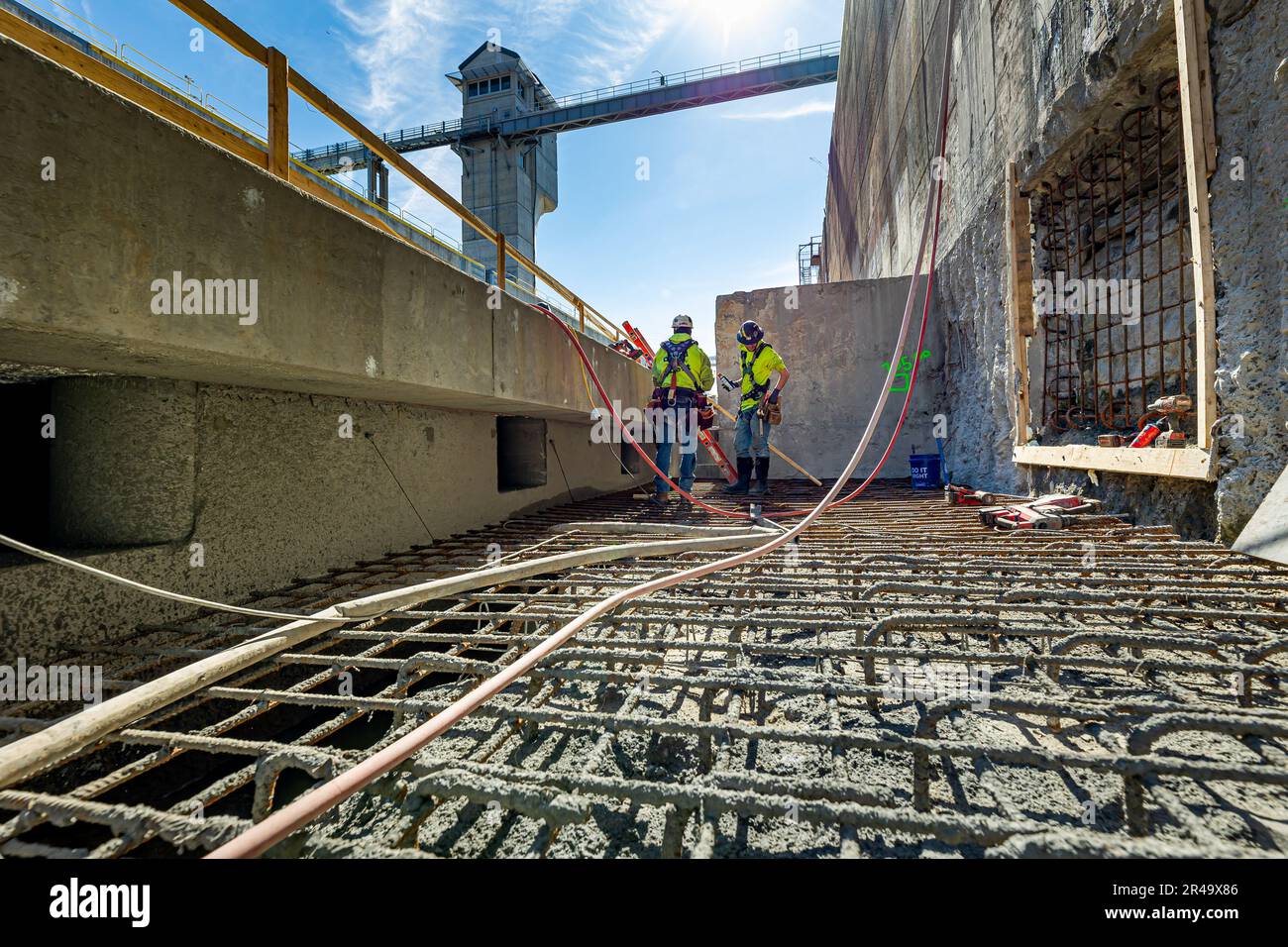 Construction laborers perform work on the chamber floor concrete infill ...