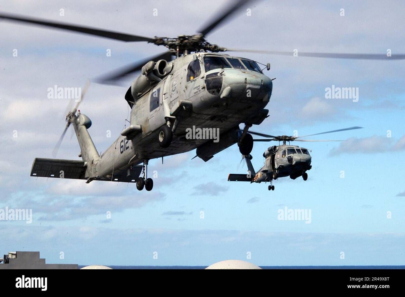 US Navy Two SH-60F Seahawks come in for a landing on the flight deck of the aircraft carrier USS ...