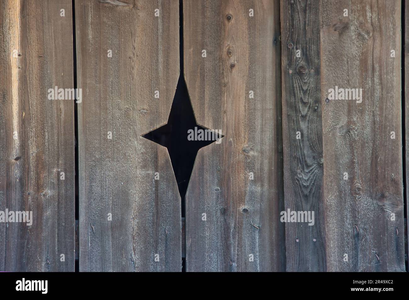 A door with a pattern of square holes set into a wooden fence Stock ...
