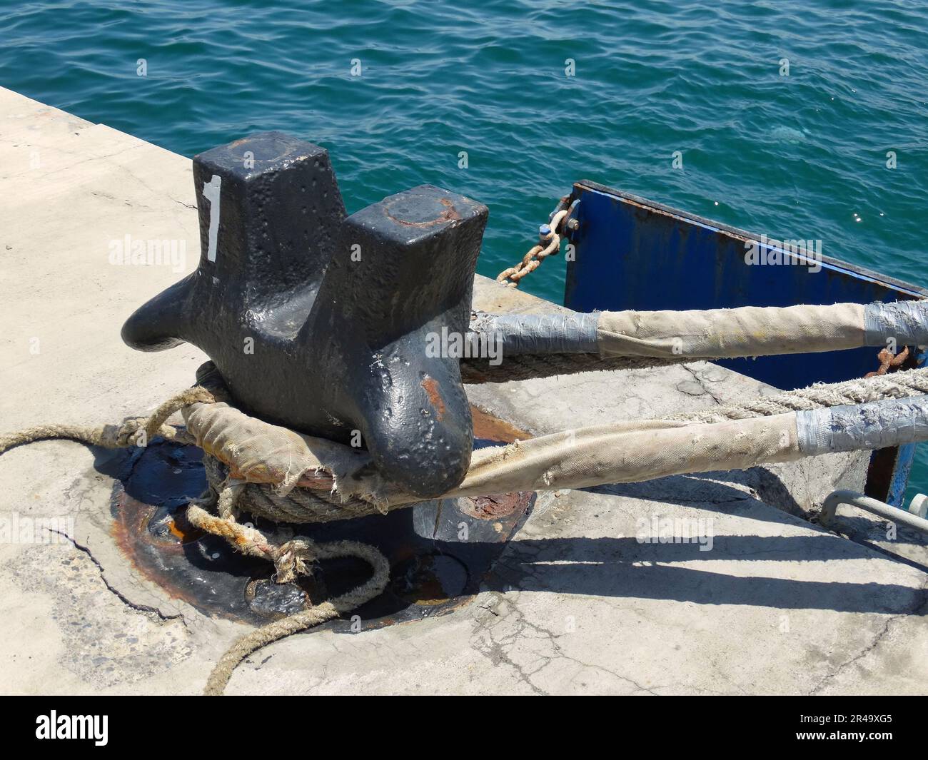 A rope tied securely around a metal post on the deck of a sailing ...