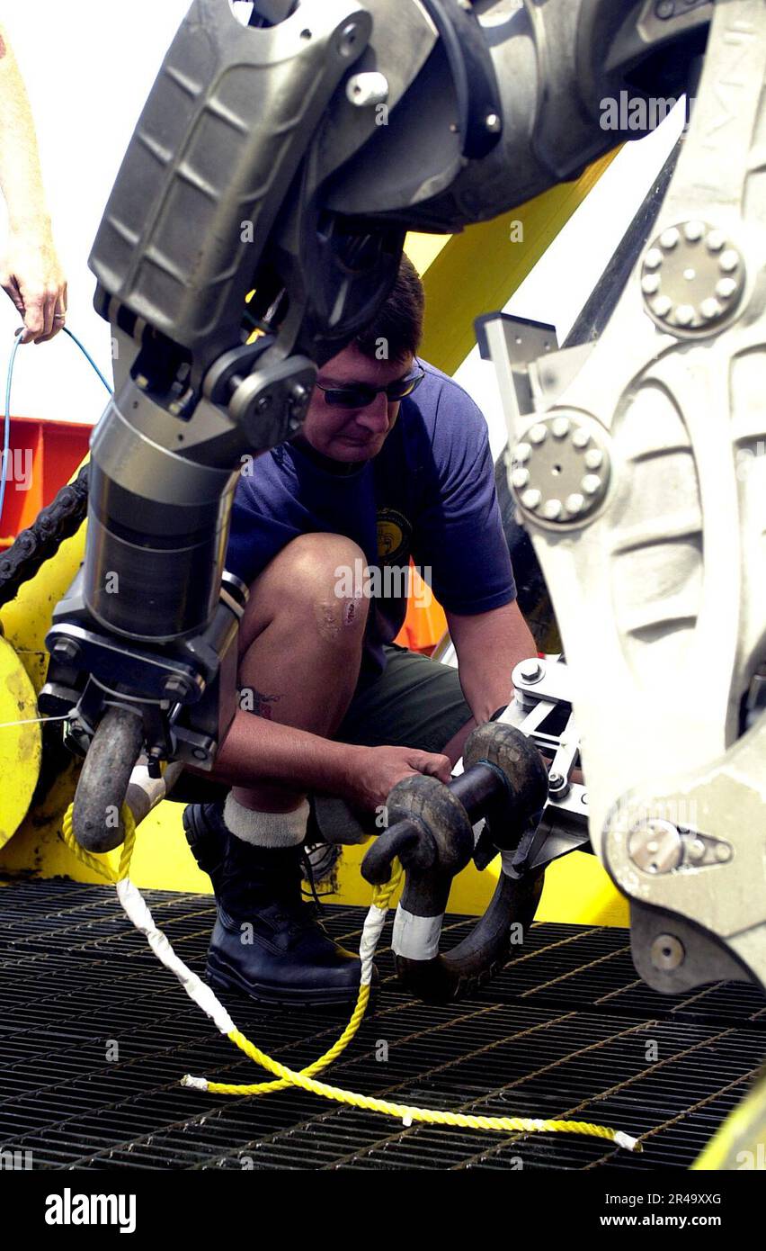 US Navy Senior Chief Machinist's Mate zip-ties a shackle to one of the ...