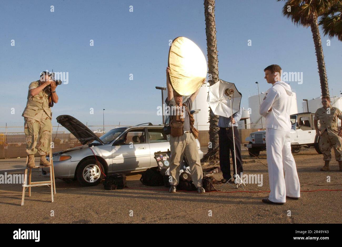 US Navy Photographer's Mate 1st Class prepares to shoot an ...