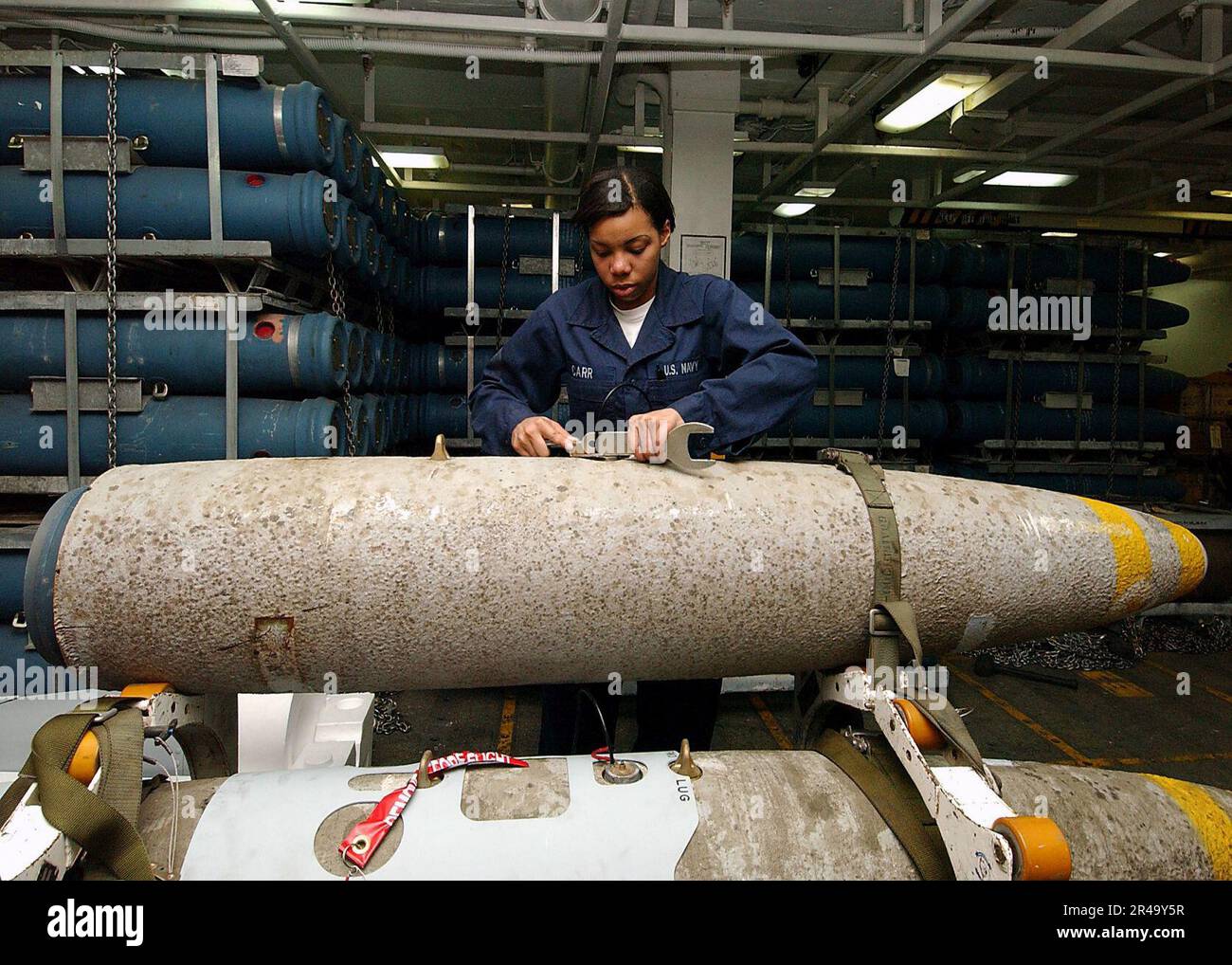 US Navy Aviation Ordnanceman Airman puts a switch on a 2,000 lbs MK-84 general-purpose bomb ...